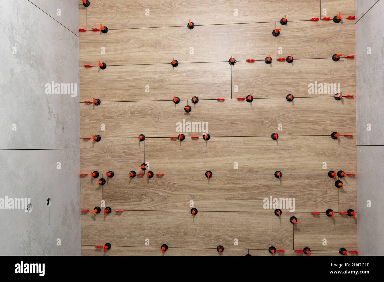 Laying tiles on the wall. Bathroom during finishing work Stock Photo ...