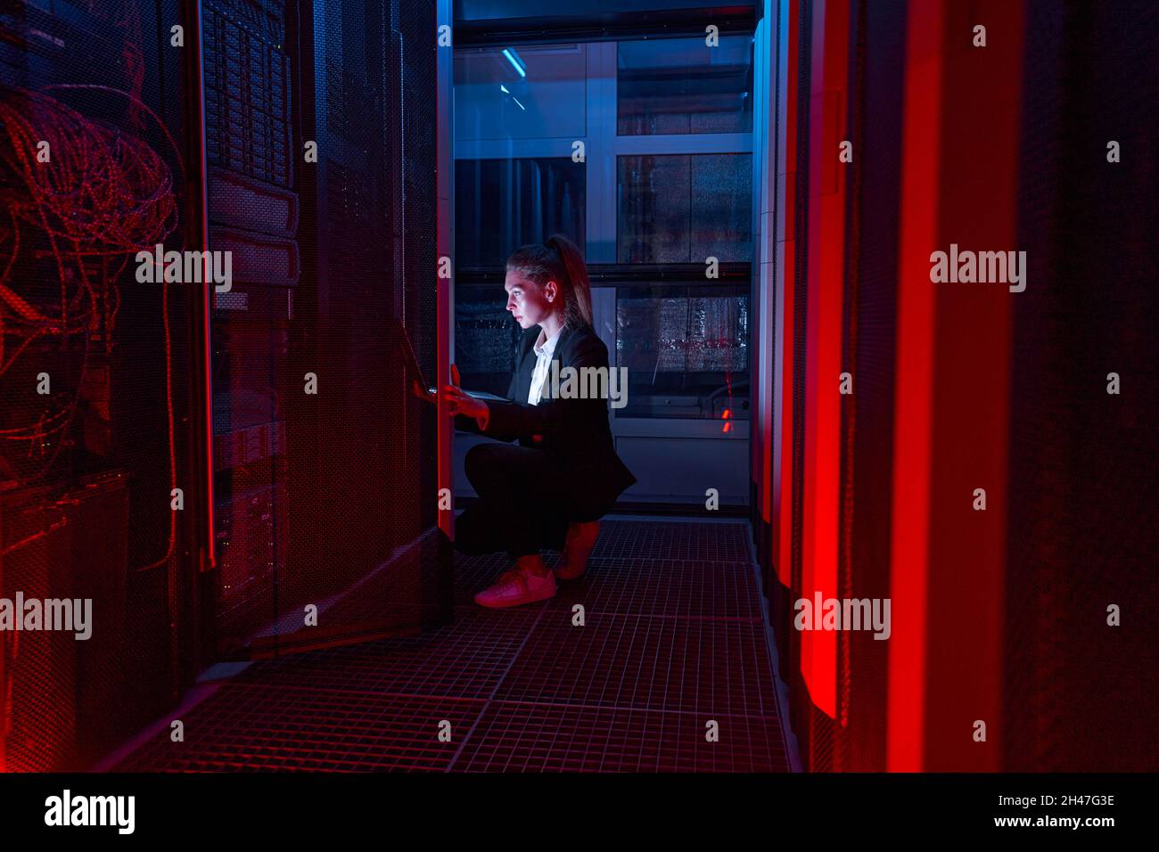 Female system manager configuring servers in server room Stock Photo ...