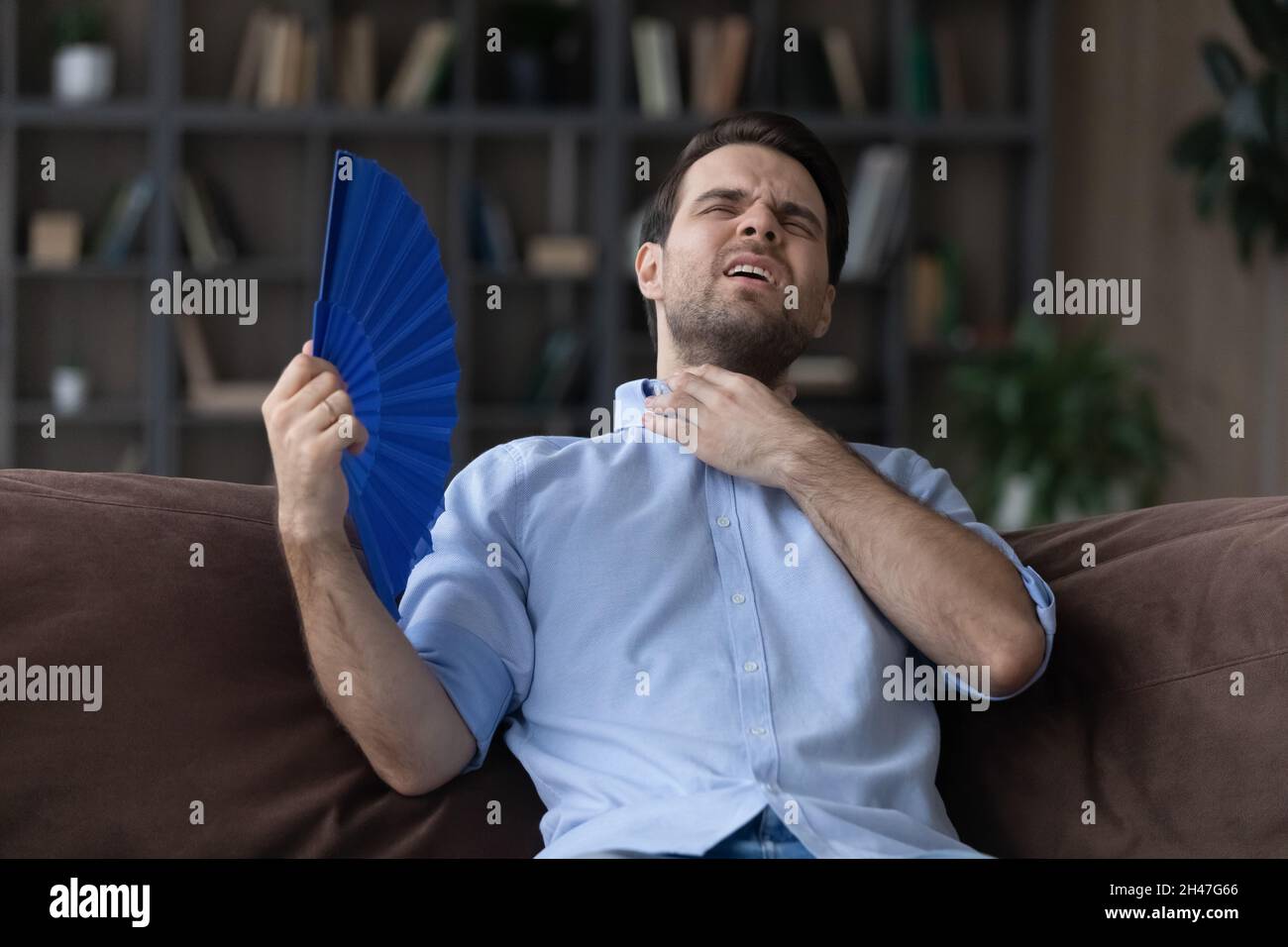 Stressed unhappy young man feeling overheated at home Stock Photo - Alamy