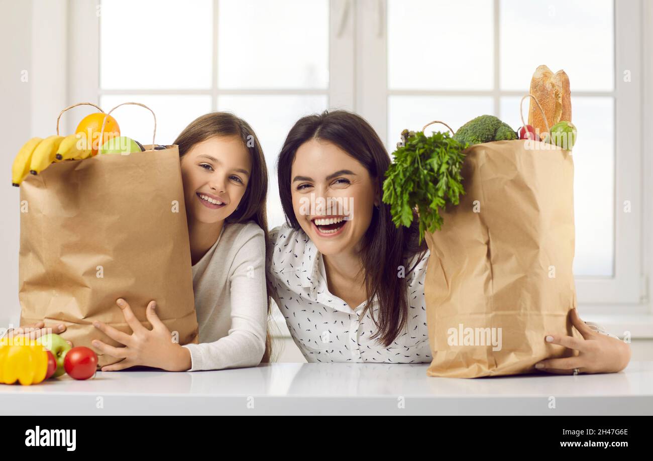 Happy mother and child with grocery bags full of healthy food from ...