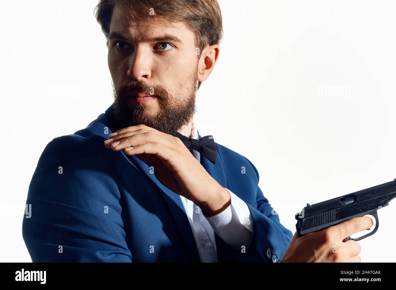 male gangster with a gun in hand light background Stock Photo - Alamy