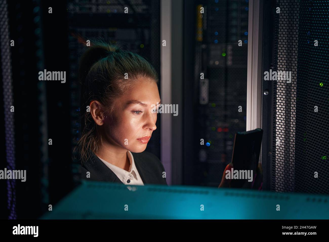 System administrator works near racks with powerful computing equipment ...