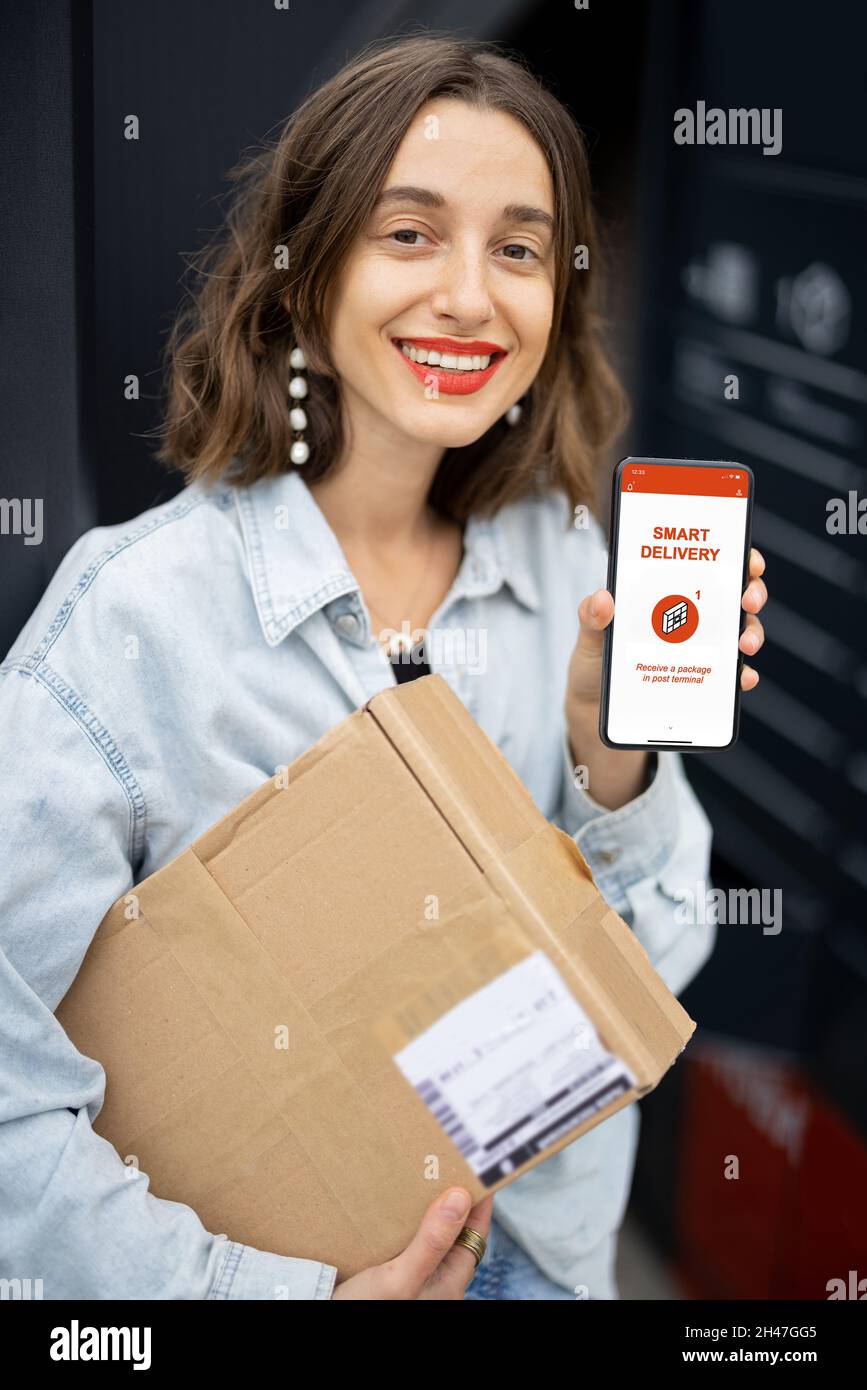 Girl with parcel and phone with smart delivery app Stock Photo - Alamy