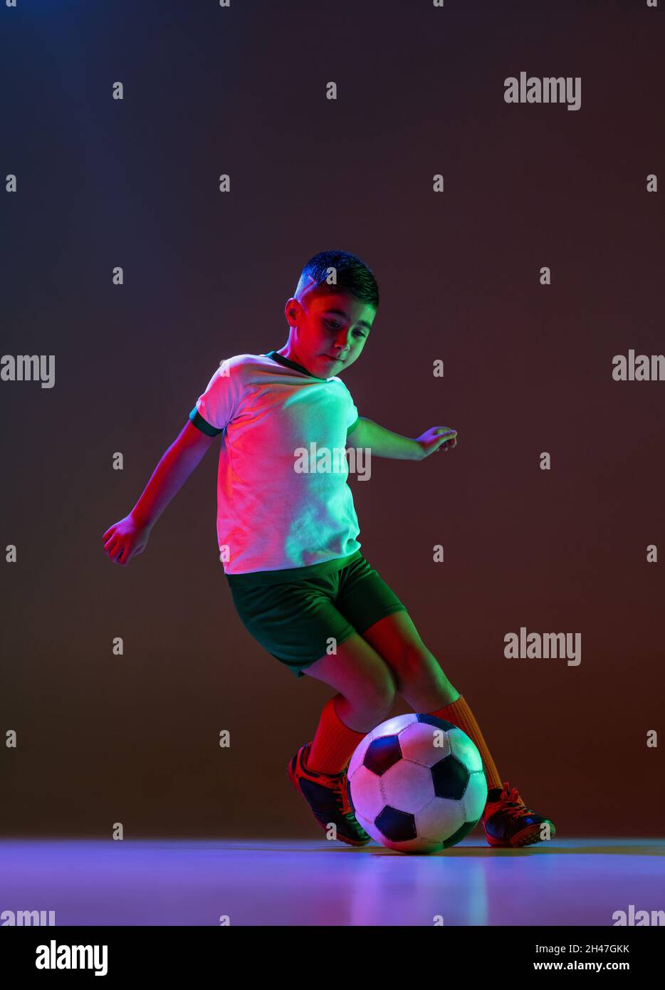 Full-length portrait of boy, child, football player in motion isolated ...