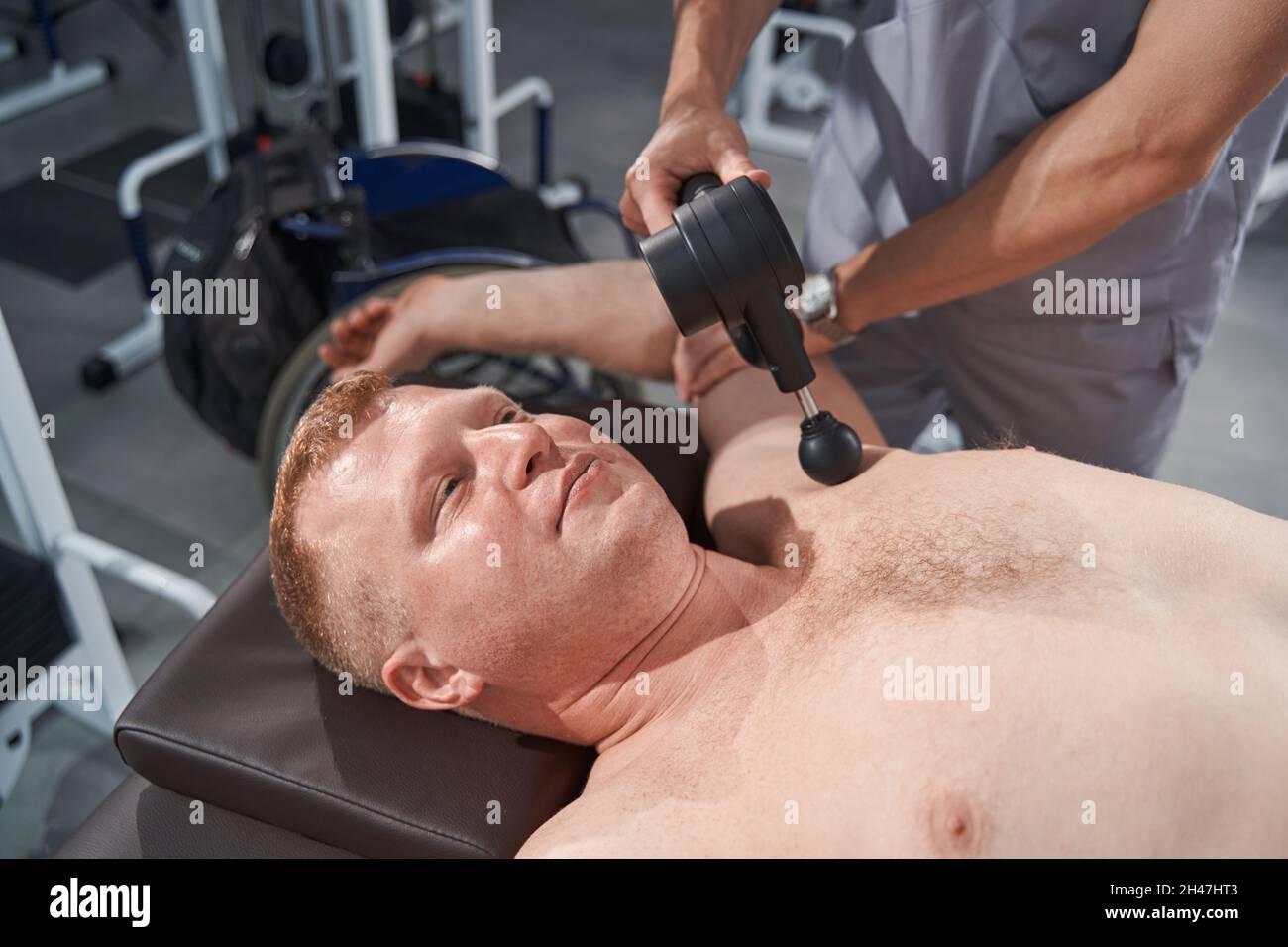 Close up masseur doing chest muscles massage with percussion tool Stock ...