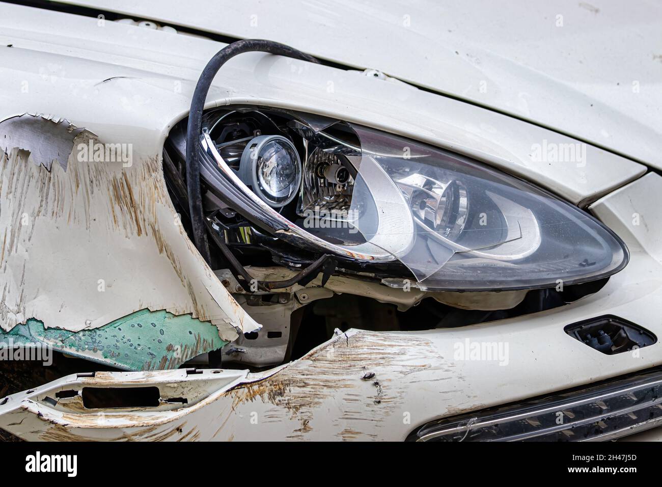 Broken car after a crash. Damaged wing and headlamp of a car, dents and ...
