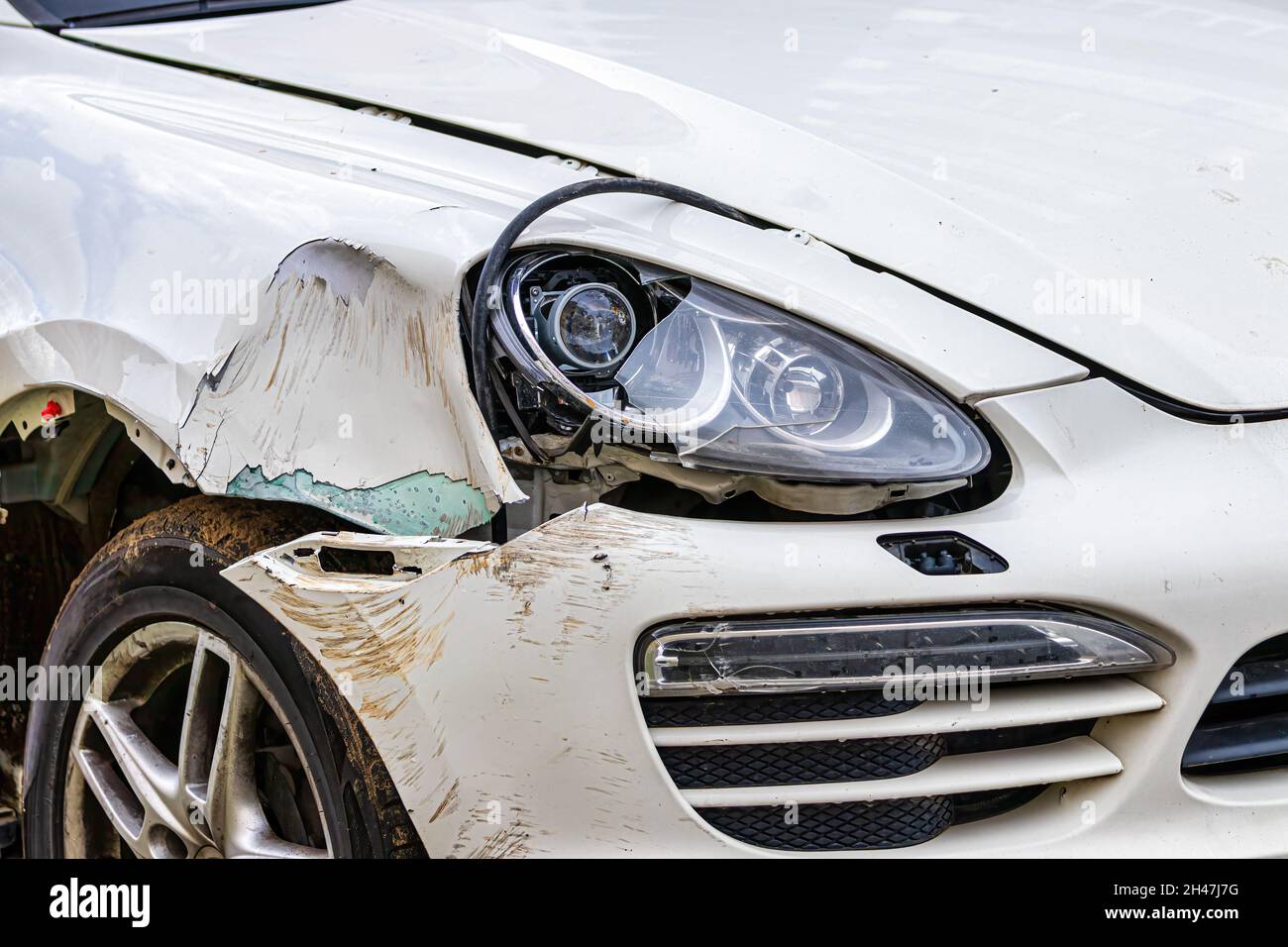 Broken car after a crash. Damaged wing and headlamp of a car, dents and ...