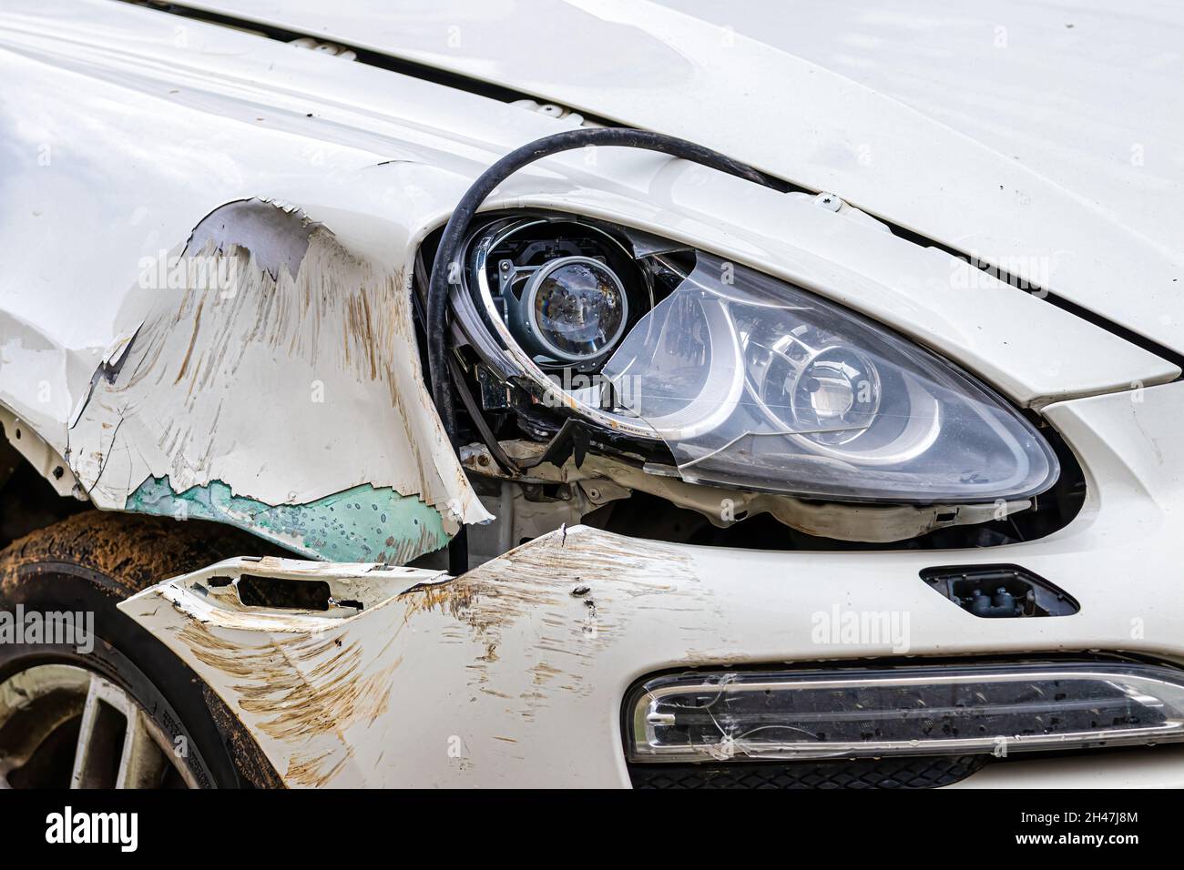 Broken car after a crash. Damaged wing and headlamp of a car, dents and ...