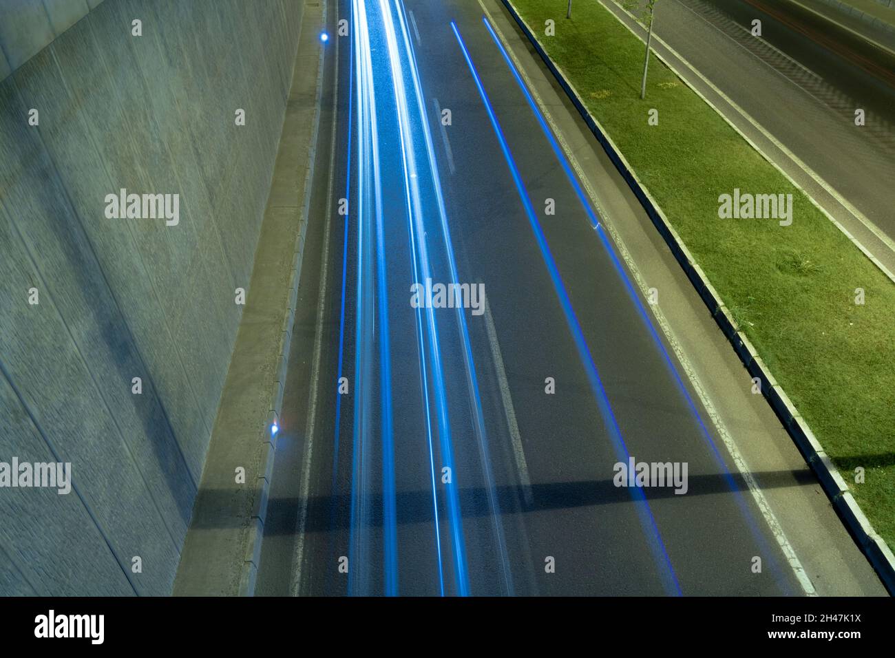Light trails on the underpass road at night. Traffic or highway ...
