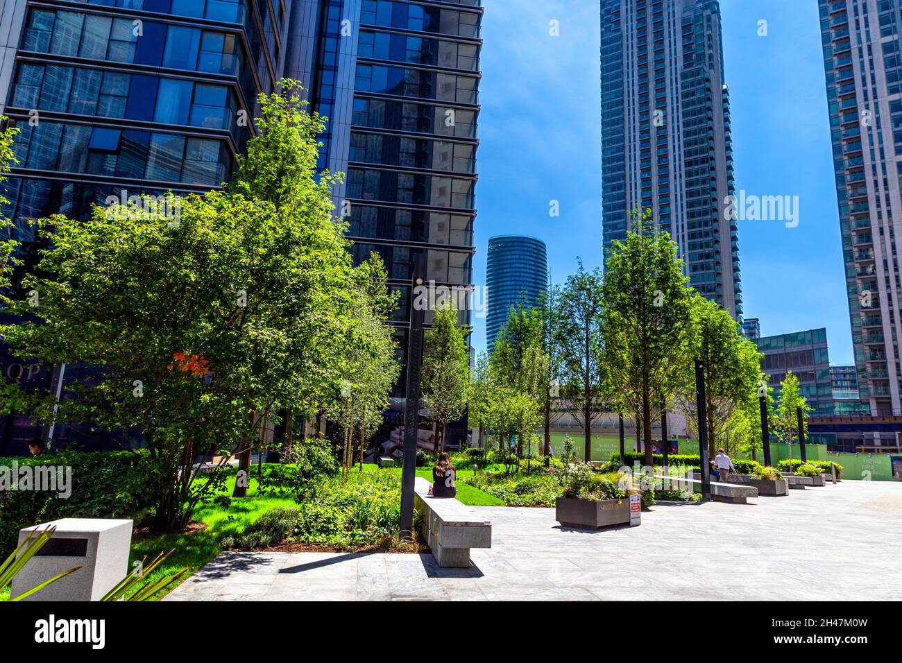 People relaxing in South Quay Square surrounded by newbuild skysrapers ...