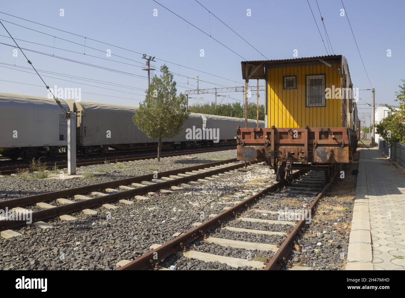 Old carriage standing in a train station on railways Stock Photo - Alamy