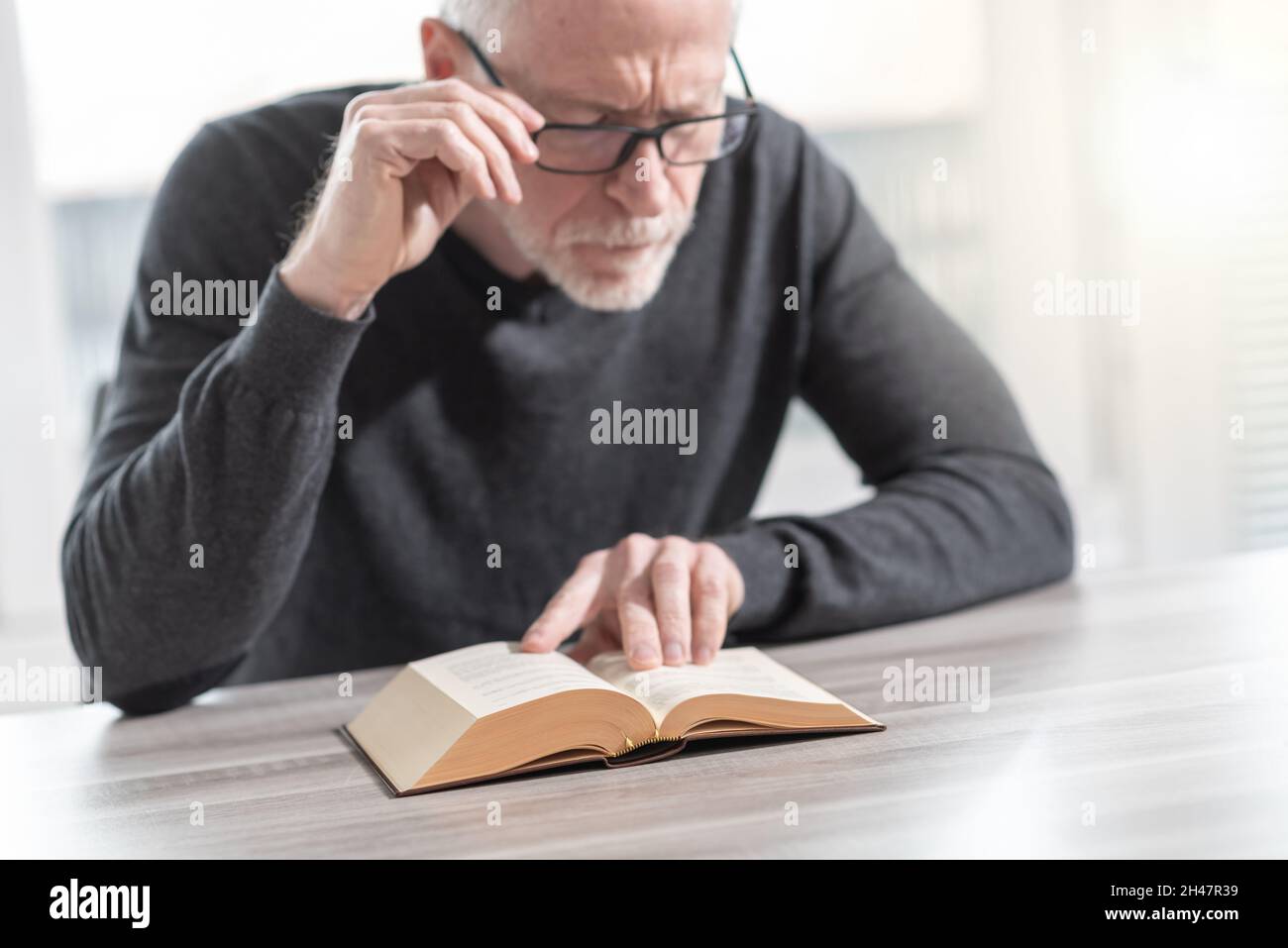 Man sitting and reading a book Stock Photo - Alamy