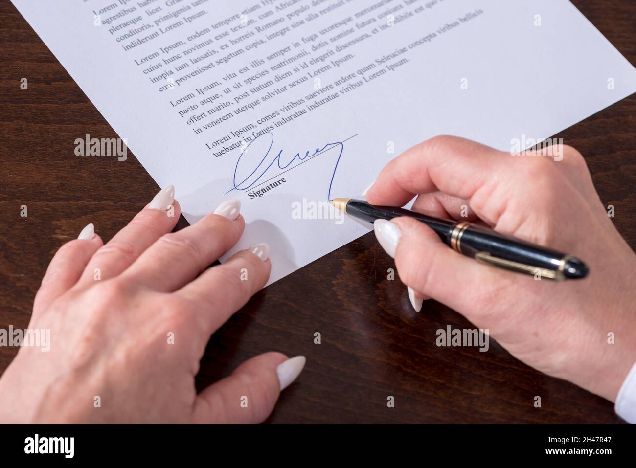 Female hand signing a contract Stock Photo - Alamy