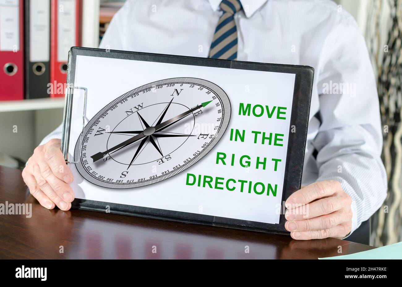 Right direction concept shown by a businessman Stock Photo - Alamy