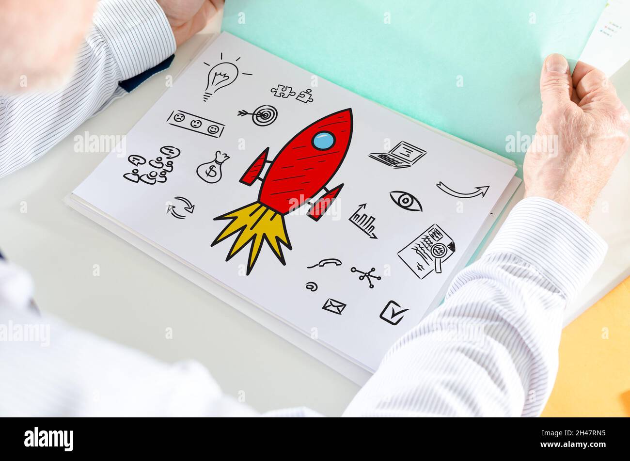 Man holding a file with start up concept Stock Photo - Alamy