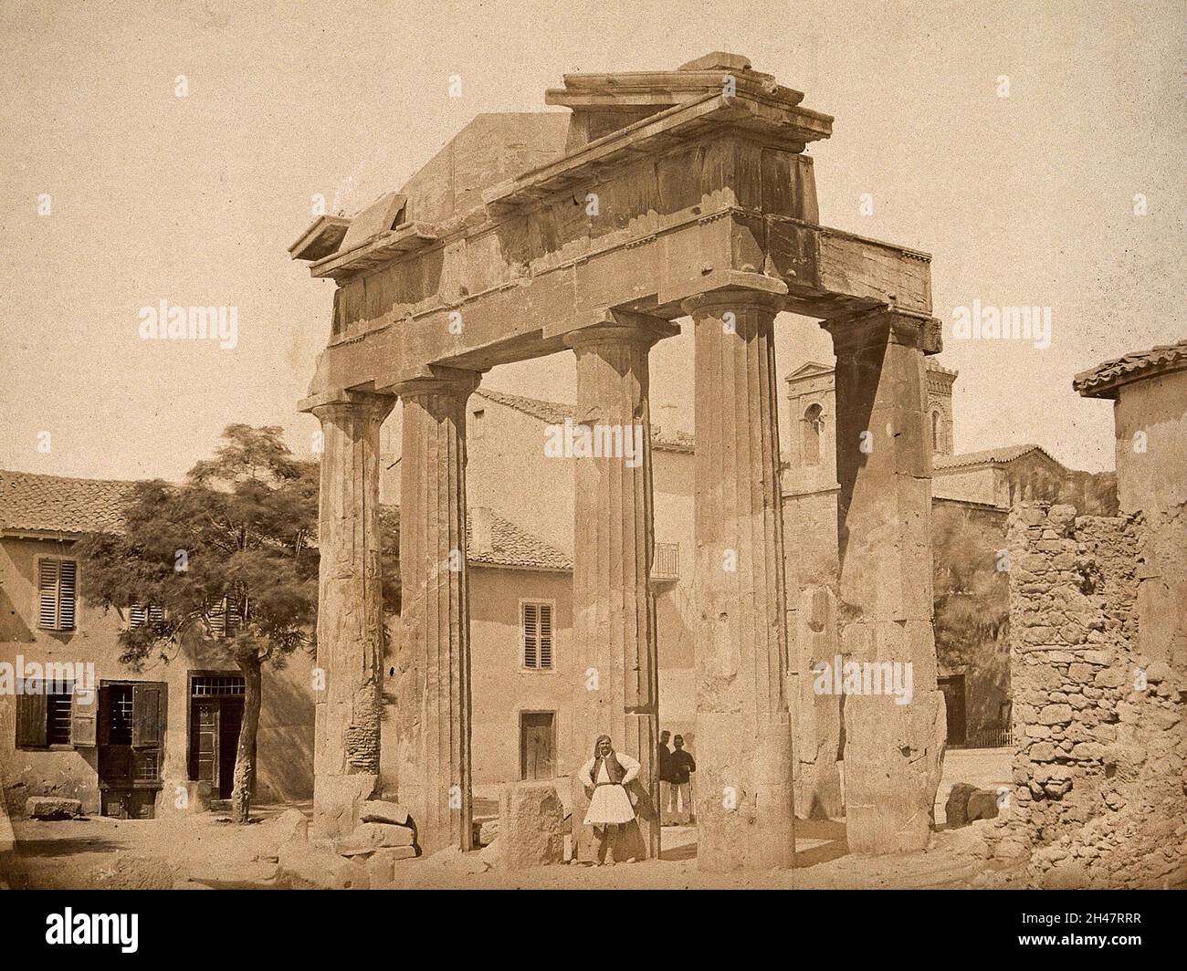 Greece (?): a pillared gateway in ruins; a man in traditional Greek ...