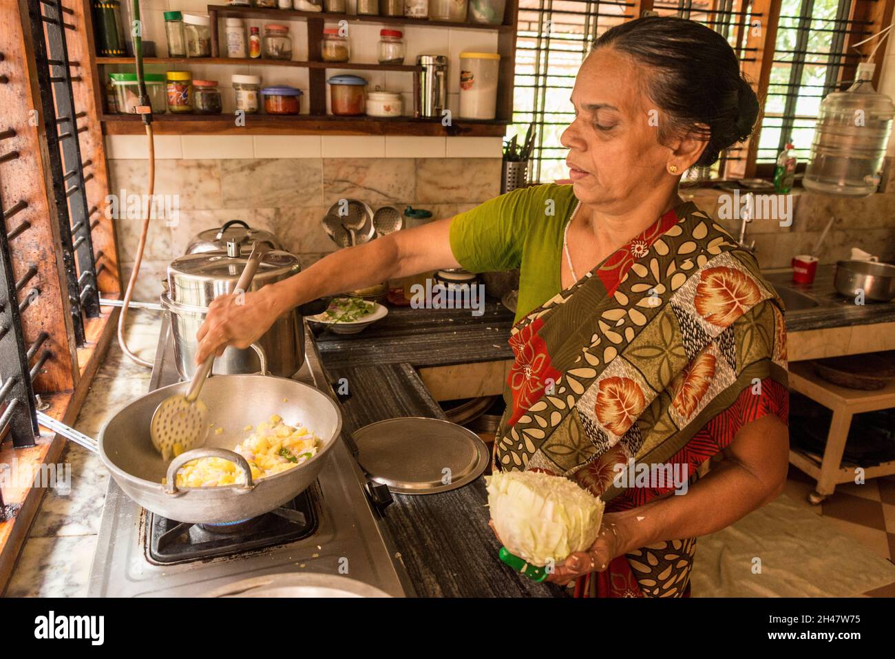 An Indian cook busy preparing a Kerala lunch for hotel guests in the ...