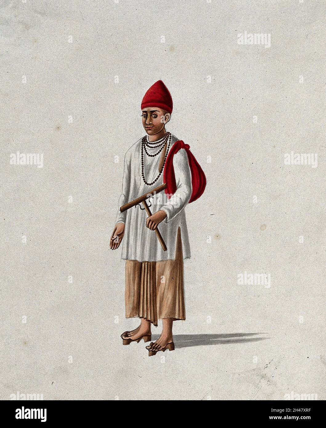 A religious man wearing a red cap and prayer beads around his neck ...