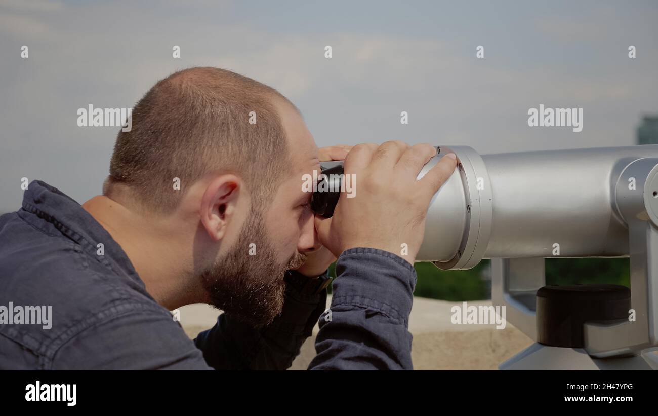 Close up of caucasian man looking through telescope lens at panoramic ...
