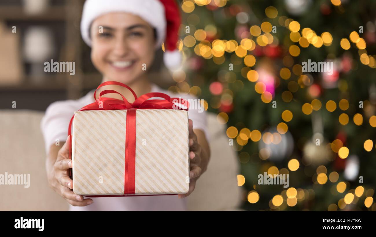 Focus on wrapped Christmas present in hands of Indian woman Stock Photo ...