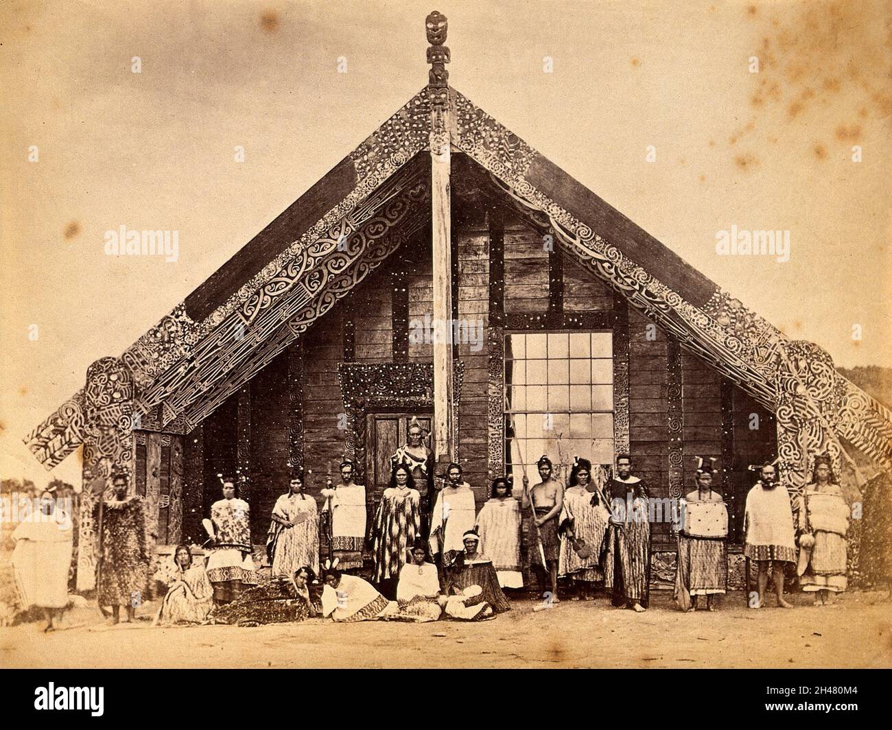 New Zealand: a group of Maori people in front of a traditional building ...