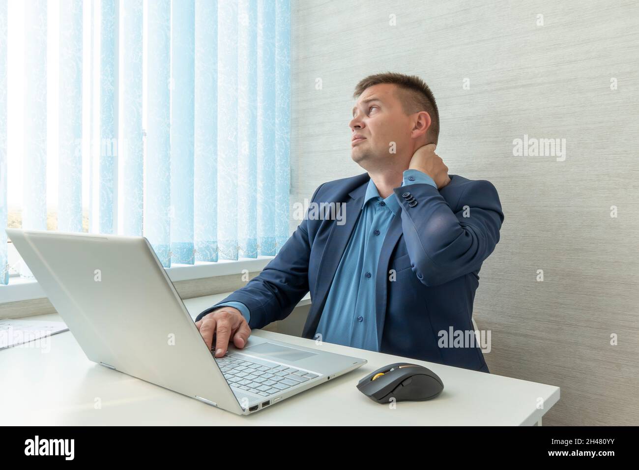 Businessman with neck pain after long hours at work. health problems ...