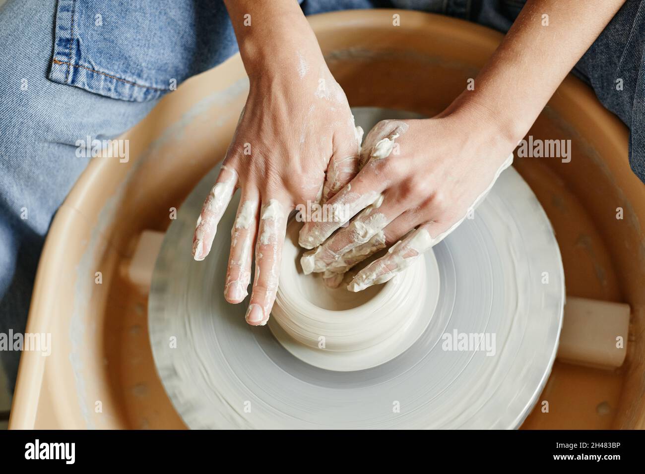 Top view close up of unrecognizable artist shaping clay on pottery ...