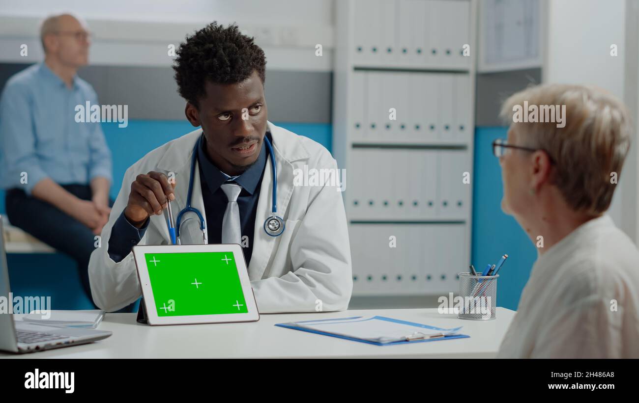 Medic using professional tablet with horizontal green screen display ...