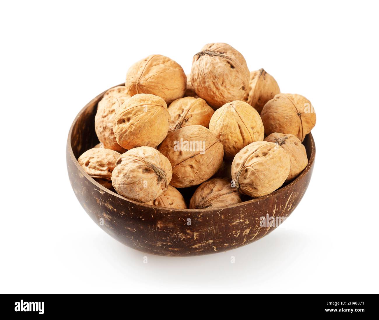Walnuts in wooden bowl isolated on a white background. Whole nuts in a ...
