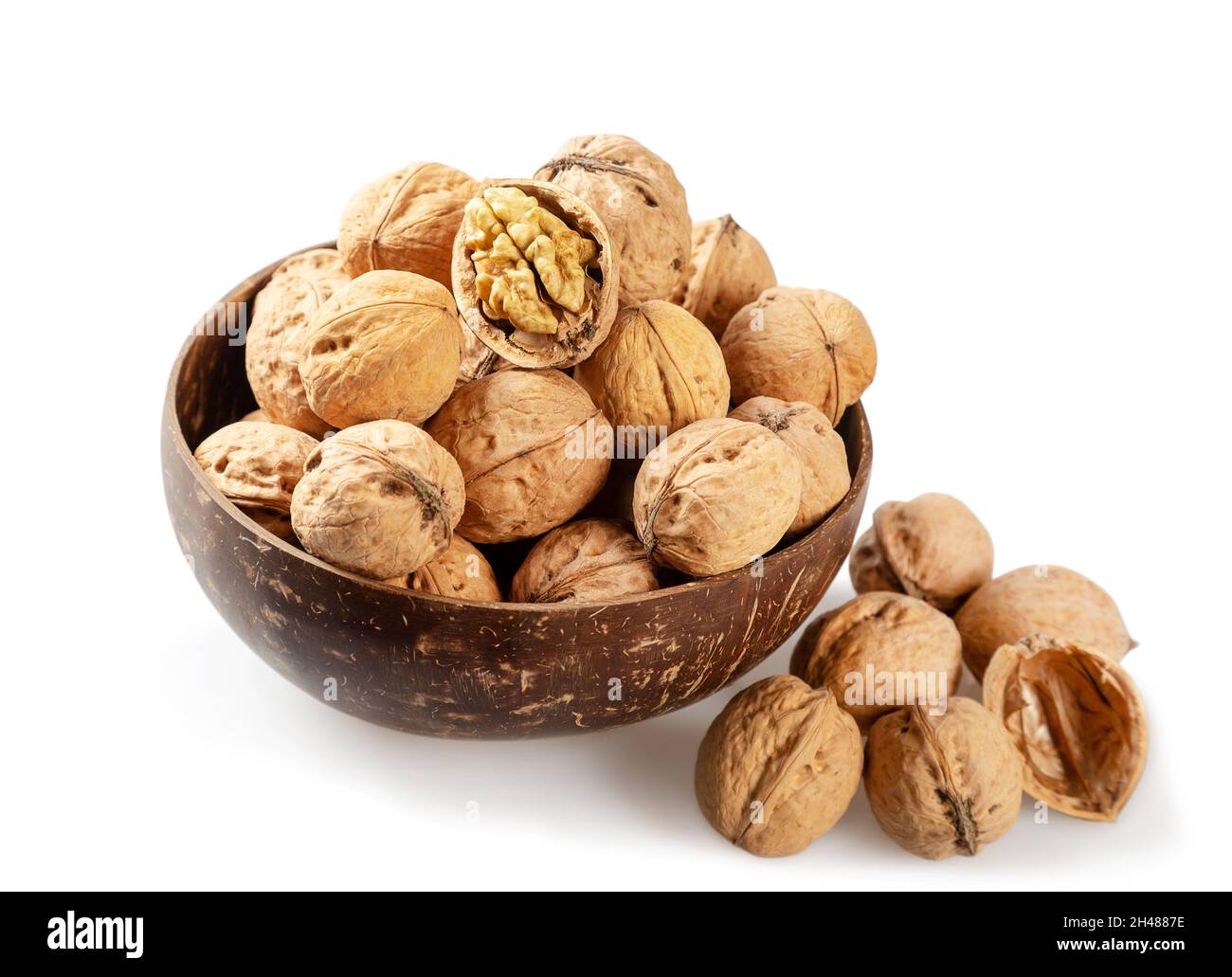 Walnuts in wooden bowl isolated on a white background. Whole nuts in a ...
