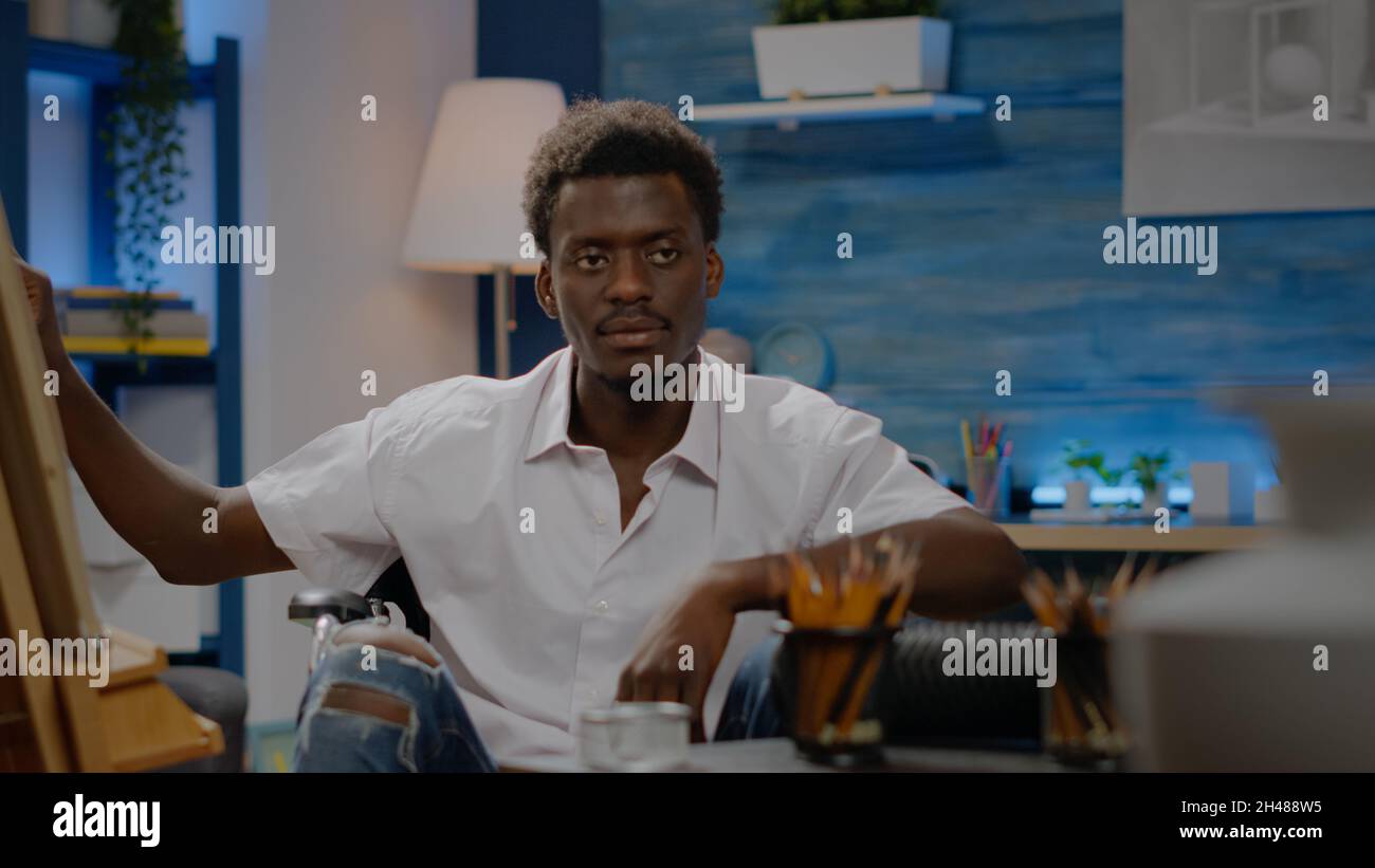 Portrait of black artist with handicap drawing in art studio at home ...