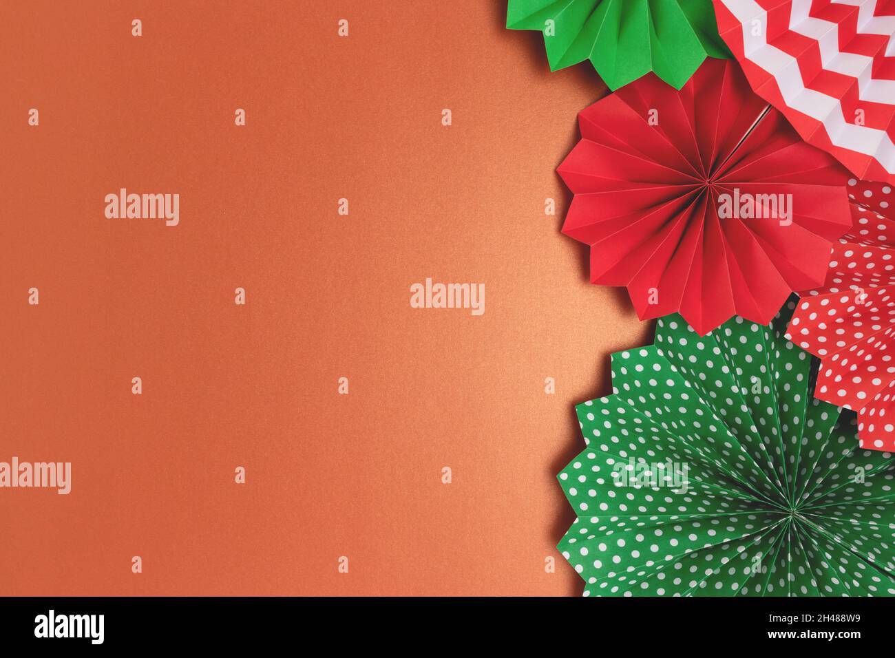 Border frame made of paper fans. Red and green decorations on a golden ...