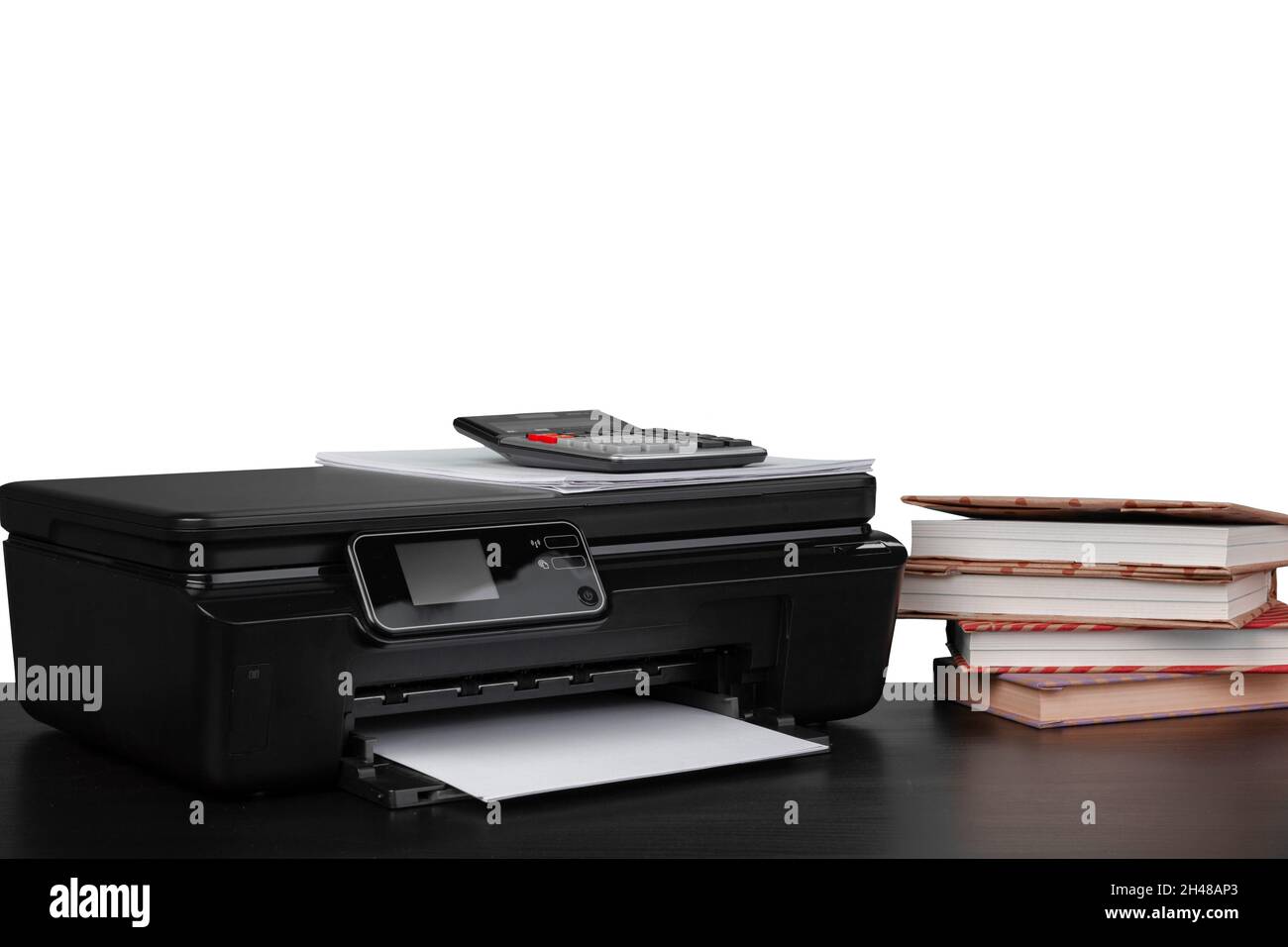 Printer and stack of books on black table against white background ...