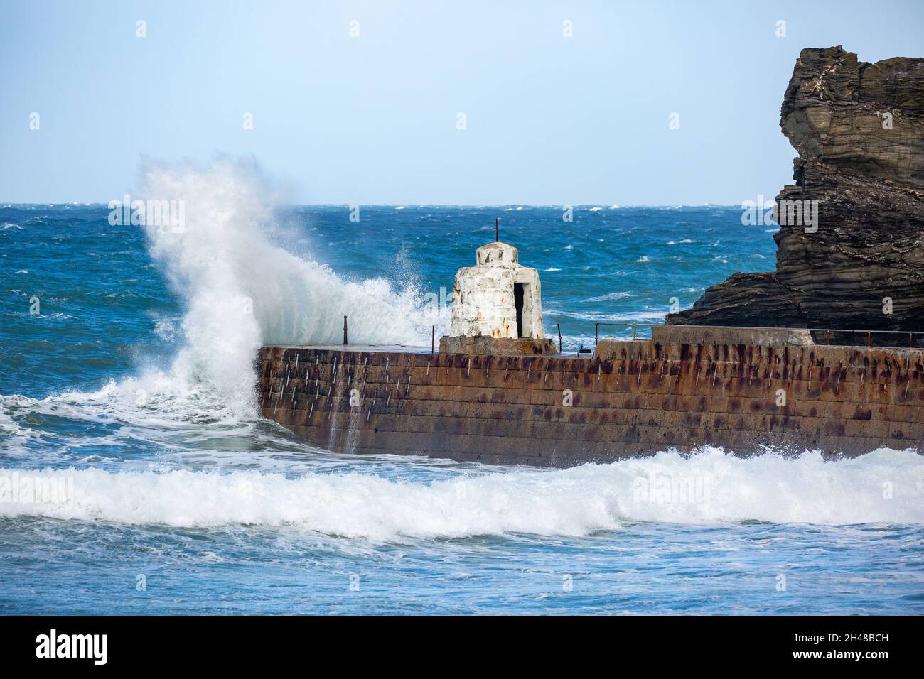 Large waves crash across the Monkey Hut at high tide in Portreath ...