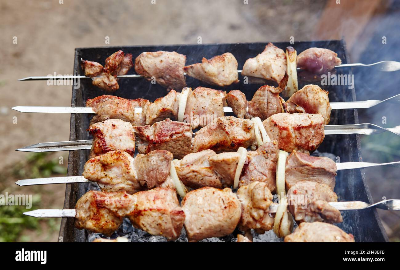 Marinated shashlik preparing on a barbecue grill over charcoal ...