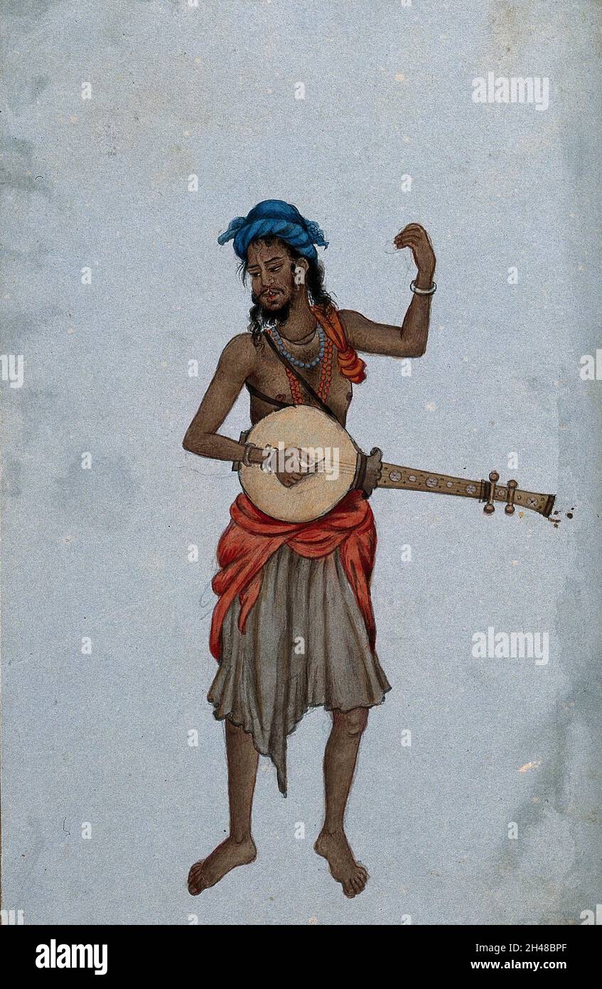 A man wearing a cloth and a turban, playing a musical instrument ...