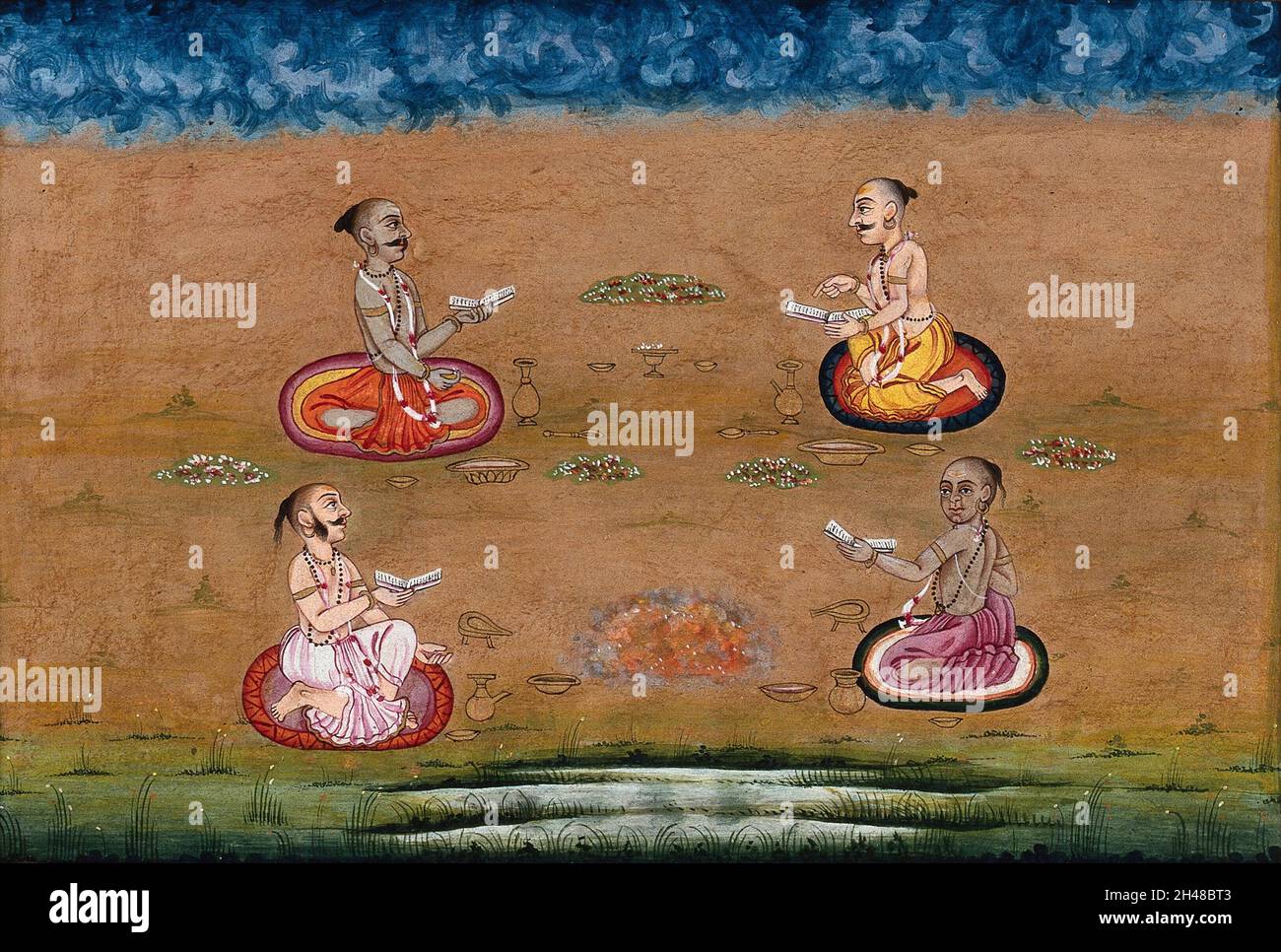 Four priests consult some writings and perform a yagna, a fire ...