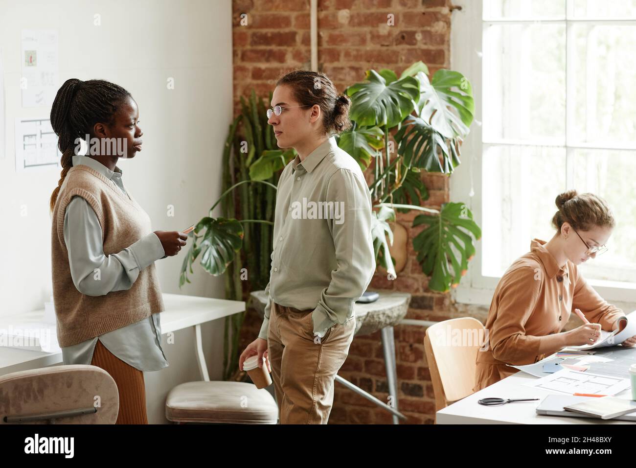 Diverse group of creative young people working on design project in ...