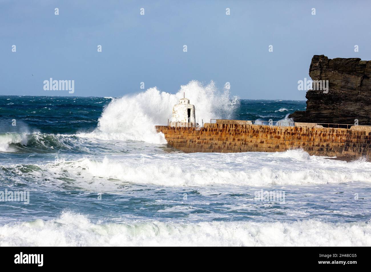 Large waves crash across the Monkey Hut at high tide in Portreath ...