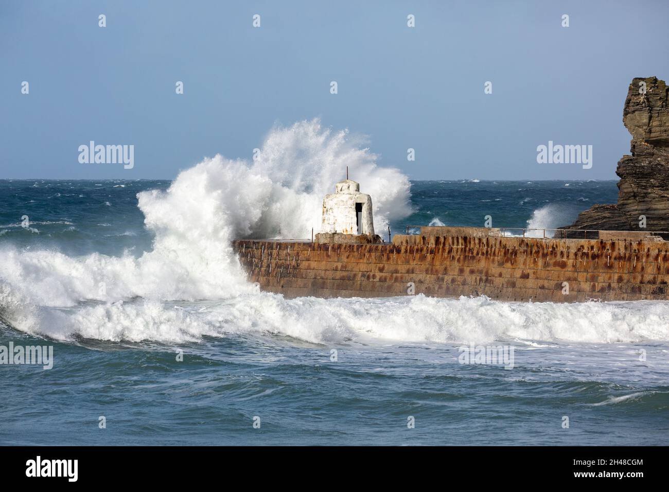 Large waves crash across the Monkey Hut at high tide in Portreath ...