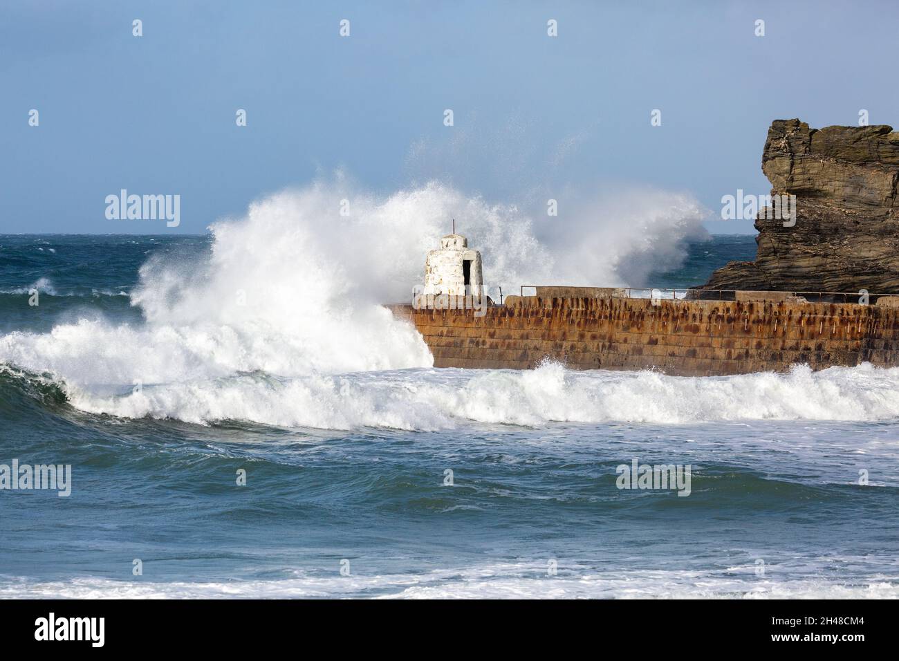 Large waves crash across the Monkey Hut at high tide in Portreath ...