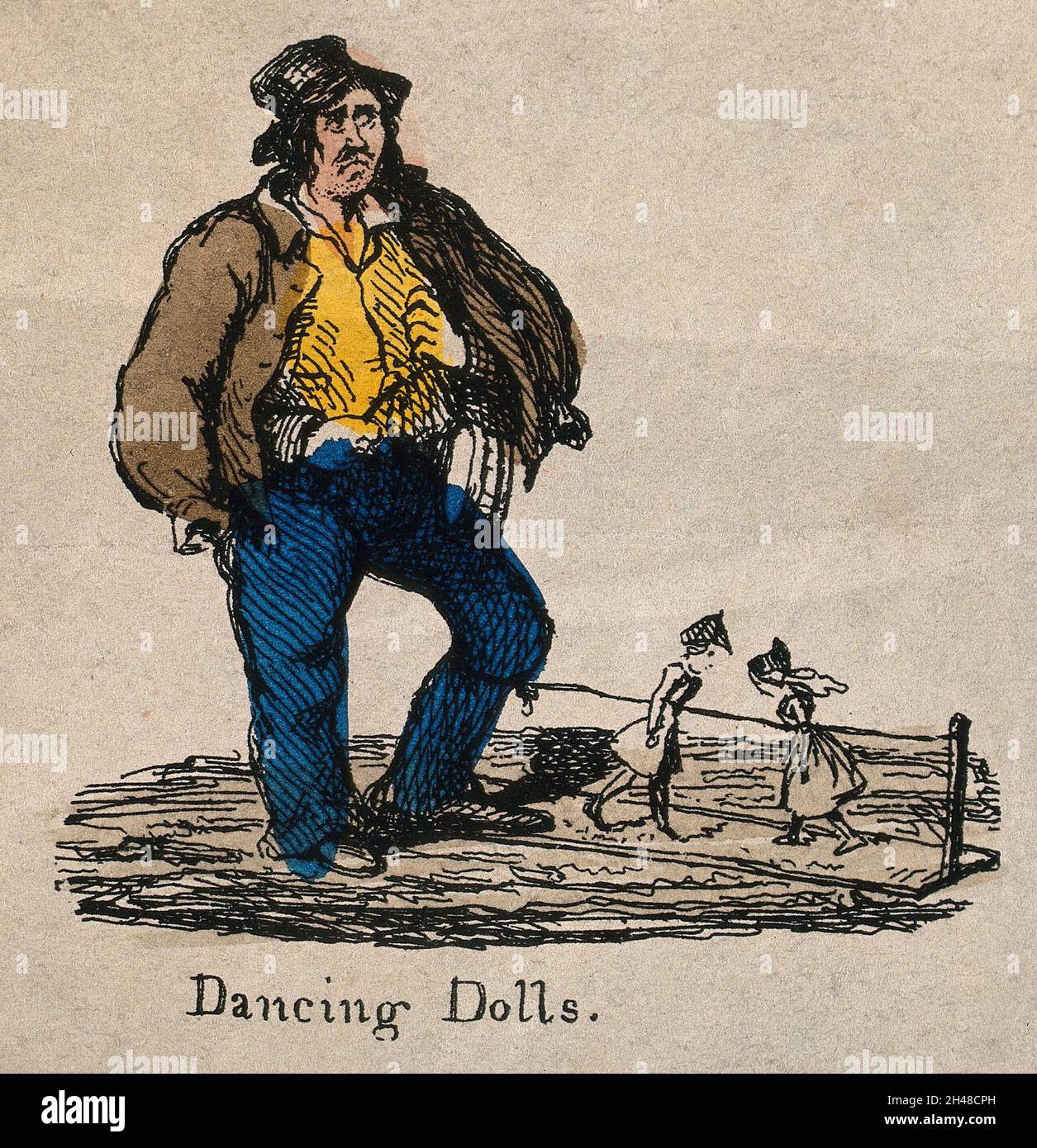 A man has two dancing dolls on a board, controlled by a string attached ...