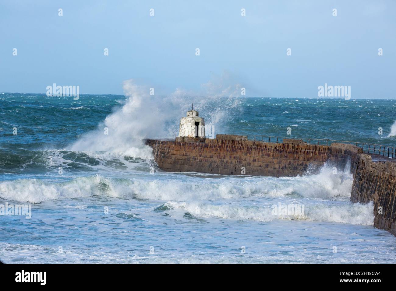 Large waves crash across the Monkey Hut at high tide in Portreath ...