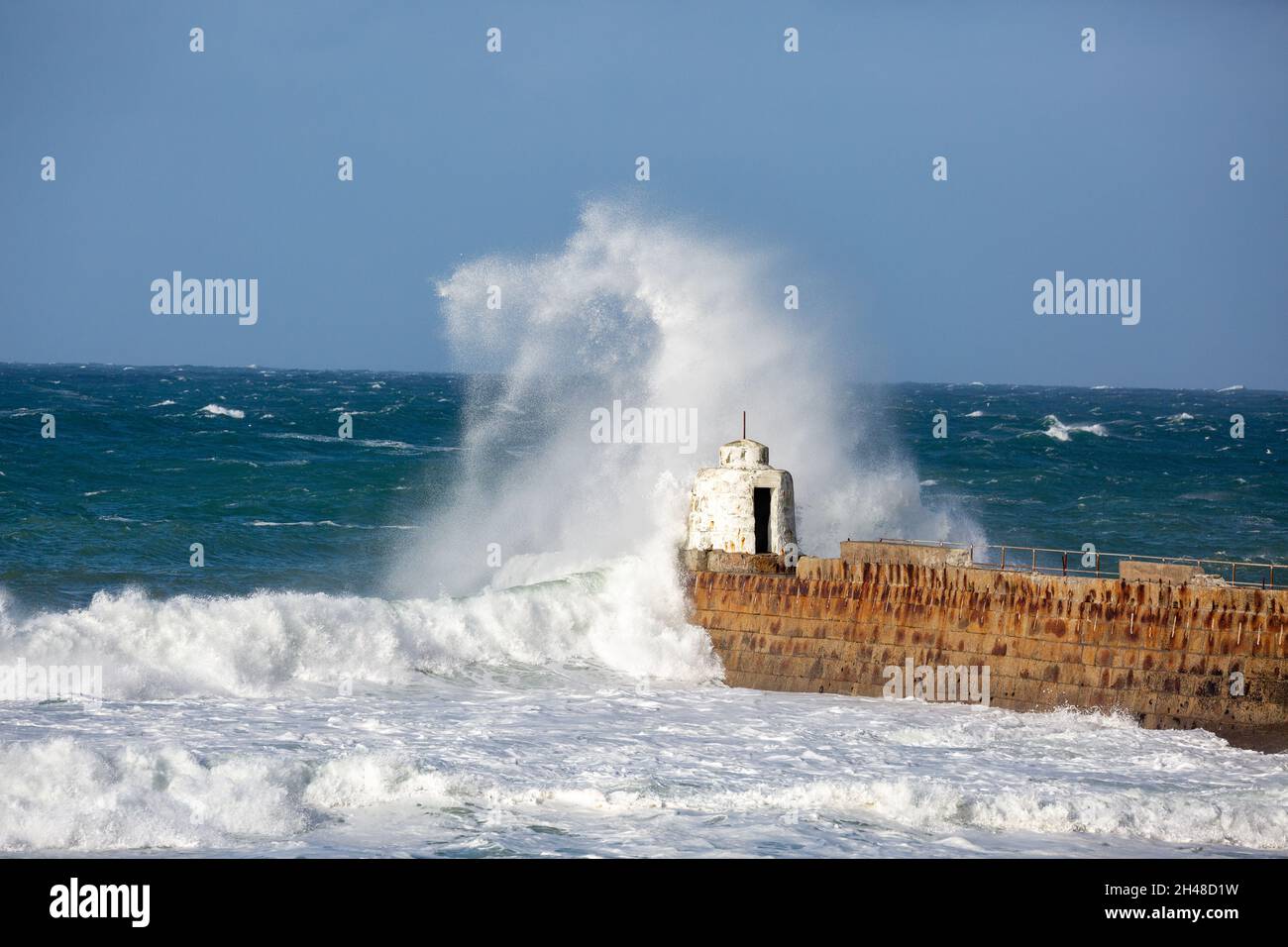 Large waves crash across the Monkey Hut at high tide in Portreath ...