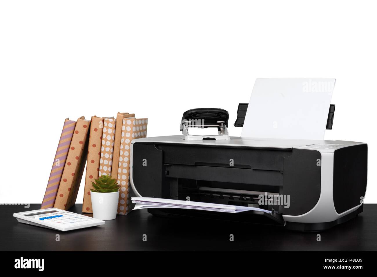 Printer and stack of books on black table against white background ...