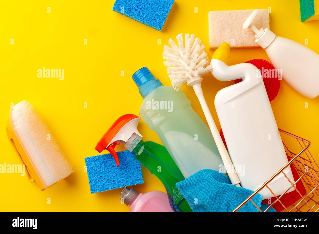Set of cleaning supplies on yellow color background Stock Photo - Alamy