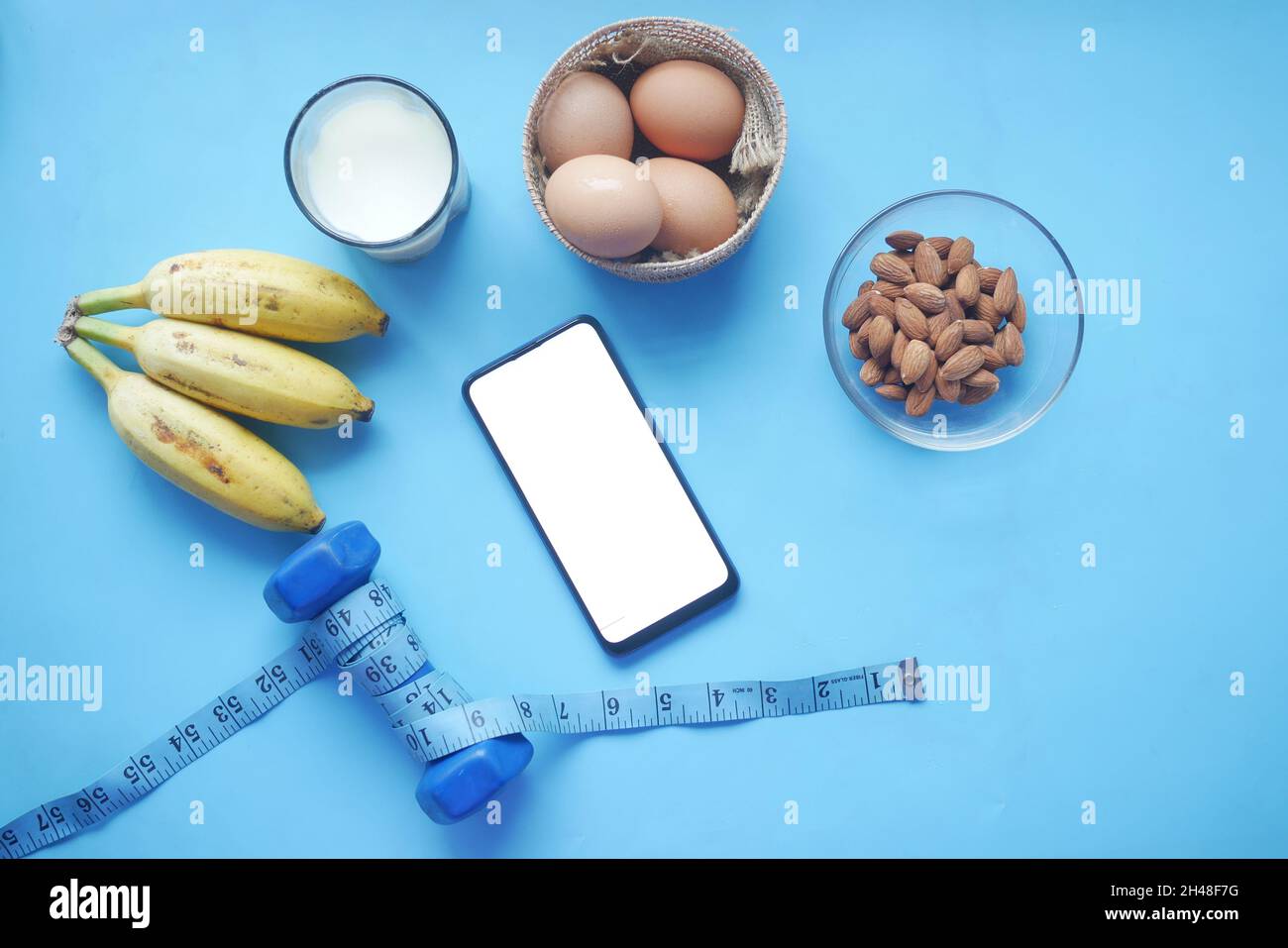 smart phone with empty screen , eggs , milk and almond nut in table ...