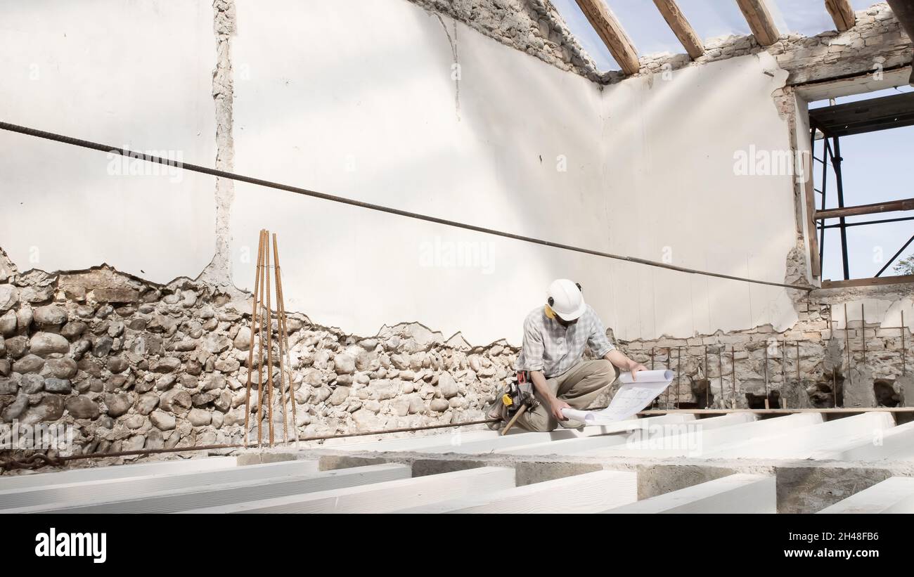 man at work, construction worker wearing helmet and looking at ...