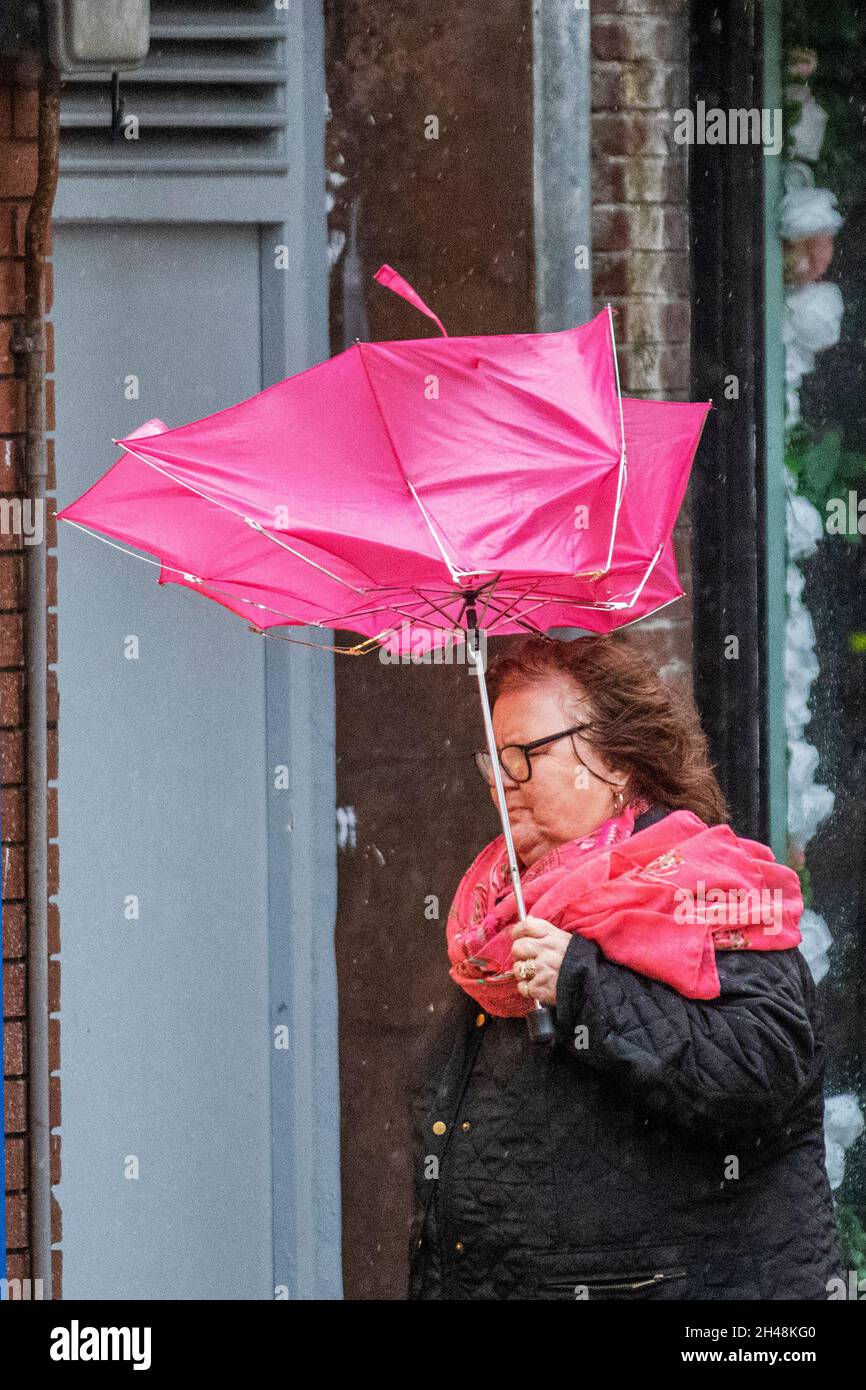 Strong winds and woman carrying inverted pink umbrella in Preston ...