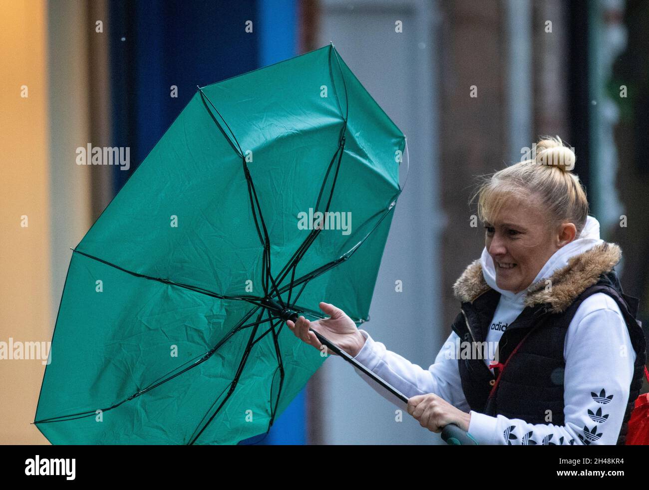 Strong winds with woman carrying inverted green umbrella in Preston ...